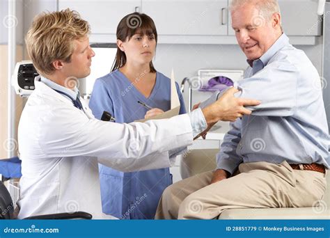 Doctor Examining Male Patient With Elbow Pain Royalty Free Stock