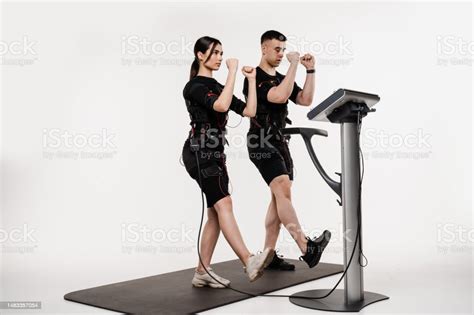 전기 근육 자극 슈트에서 Ems 스포츠 훈련 Ems 정장을 입은 남자와 여자는 흰색 배경에 근육을 자극하기 위해 전기 충격을 사용한다 18 19세에 대한 스톡 사진 및 기타