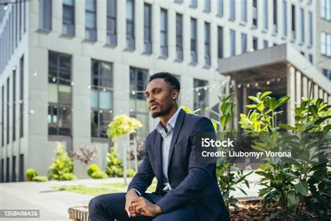 도시 거리 배경에 도시 공원 벤치에 앉아 야외에서 대마초를 흡연 아프리카 계 미국인 사업가 남성 직원 사업가 양복을 입은 사무실