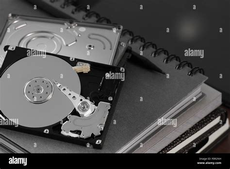 Close Up Of Open Computer Hard Disk Drive With Social Network Diagram On Desk And Notebook Stock