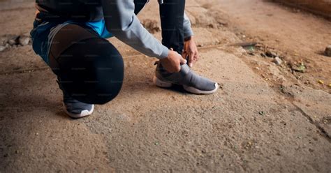 스포티한 활동적인 아프리카계 미국인 러너 맨이 웅크리고 있고 버려진 햇볕이 잘 드는 장소에서 벨크로 운동화를 묶는 모습을 닫습니다 사진 Unsplash의 세르비아 이미지