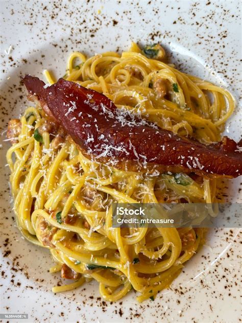 이탈리안 레스토랑에서 크림 스파게티 까르보나라 레시피의 얼룩덜룩한 흰색 접시의 전체 프레임 이미지 판체타와 바삭한 베이컨 러셔가 특징인 파스타 요리를 외식하고 높은 전망 0