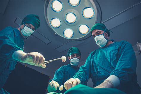 수술실에서 의사 외과 의사 수술 그룹 현대 수술실에서 밝은 전기 램프 아래에서 수술을 수행하는 숙련 된 외과 의사의 수평 촬영 30 34세에 대한 스톡 사진 및 기타 이미지