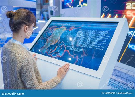 Woman Using Interactive Touchscreen Display At Modern Museum Or