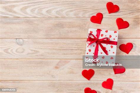 발렌타인 데이 또는 다른 휴일 수 제 종이에으로 현재 휴가 래퍼에 빨간 하트와 선물 상자 디자인을 위한 오렌지 나무 테이블 복사 공간 평면도 빈 공간에 선물 상자를 제시