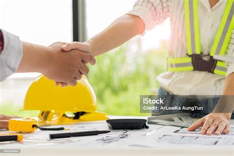 전문 건축가 및 엔지니어가 평면도 작업에 전념하는 작업장 엔지니어링 객체와 손을 잡고 건물 건설에서 주택 설계를 초안하는 건축 엔지니어 부동산 개발업자에 대한 스톡 사진 및