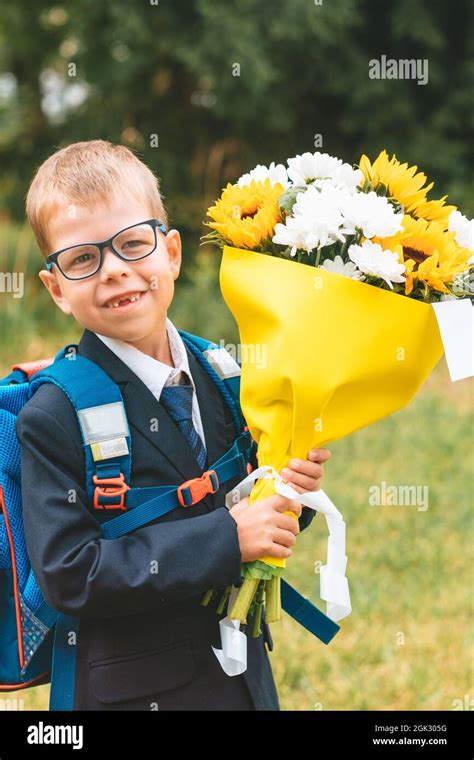 Small Smiling Boy With Flowers Ready To Go In First Class In School A