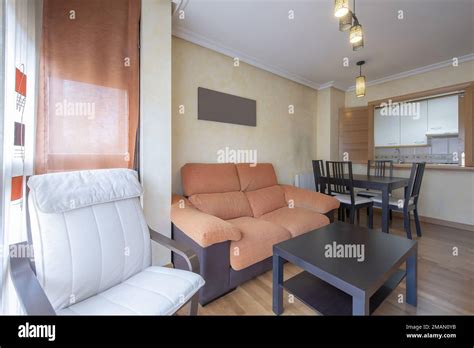 Apartment With A Small Living Room With A Serving Hatch To The Kitchen And Black Cabinets Stock