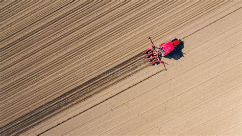 aerial top view of tractor as dragging a sowing machine over