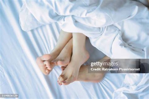 Close Up Barefoot Legs Of Lesbian Couple Lovers Sleep On White Bed In