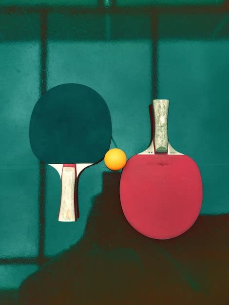 Premium Photo High Angle View Of Ball And Tennis Racket On Table