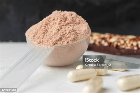 유청 또는 콩 단백질 분리 초콜릿 단백질 바 아미노산과 크레아틴의 흰색 캡슐 흰색 테이블에 보디 빌딩 식품 보충제 및 복사 공간이있는 어두운 배경 크레아틴에 대한 스톡 사진