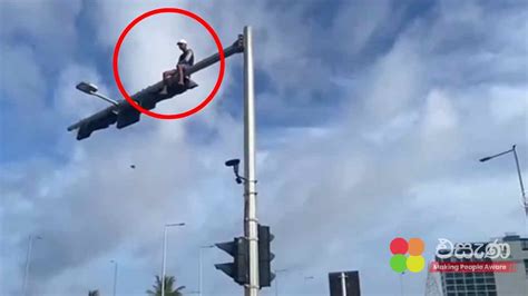 ජනාධිපති ලේකම් කාර්යාලය ඉදිරිපිට මාර්ග සංඥා කණුවකට නැඟුණු පුද්ගලයෙක් පොලිස් භාරයට