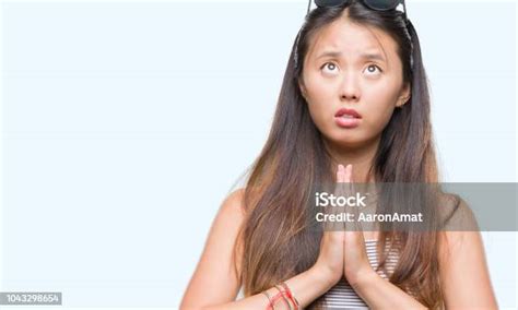 젊은 아시아 여자 얼굴 매우 감정적이 고 걱정에 희망 식 함께 손으로 기도하 고 구걸 격리 된 배경 위에 선글라스를 착용 용