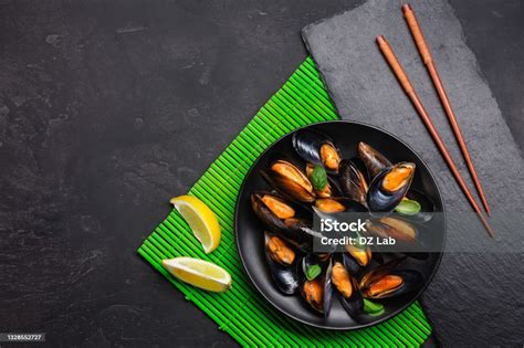 해산물 홍합 바질 잎은 녹색 대나무 매트와 돌 테이블에 레몬과 젓가락과 검은 접시에 바질 잎 고급 요리에 대한 스톡 사진 및 기타 이미지 Istock