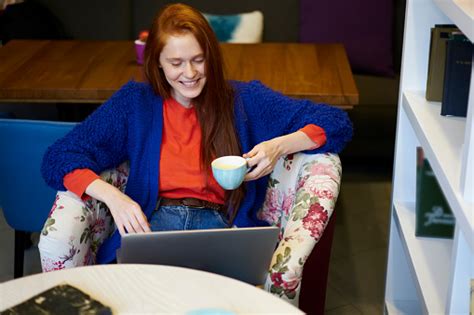 화려한 긴 붉은 머리 마시는 아로마 커피와 카메라 보고 Coworking Wifi 존에서 공간에 앉아 웃 고 하면서 현대 컴퓨터에 명랑 한 십 대의 반 길이 초상화 Stem