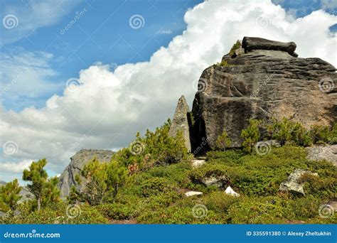 A Huge Rectangular Granite Monolith On Top Of A Cliff Overgrown With