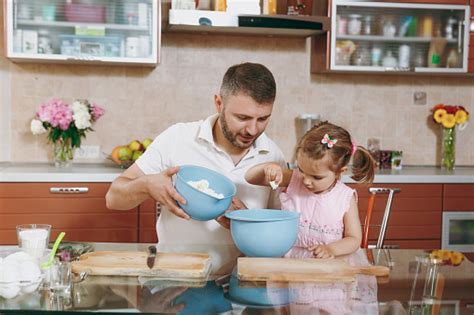 작은 아이 여자 요리 하는 남자와 부엌 식탁에 그릇에 코 티 지 치즈를 따른다 행복 한 가족 아빠 자식 딸 주말 아침에 음식을 조리 아버지의 날 휴일입니다 부모 어린