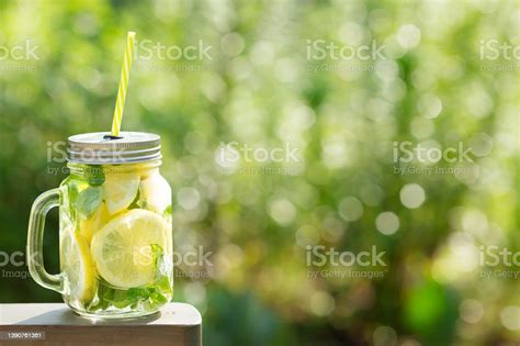 여름날 열 레몬 라임 민트와 함께 세련된 유리에 상쾌한 칵테일을 제공하는 모히토 음료의 클로즈업 아름답고 밝은 다채로운 배경