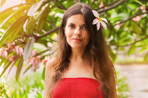 분홍색 꽃으로 덮인 열대 나무 근처에서 빨간 드레스와 여름 모자를 쓴 여성 꽃 의 시간은 가장 아름답습니다 Red Dress에 대한 스톡 사진 및 기타 이미지 Istock