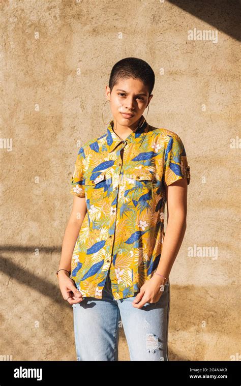 Young Bisexual Ethnic Female With Short Hair In Earrings Looking At