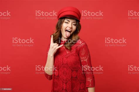 스튜디오에서 밝은 빨간색 벽 배경에 고립 된 제스처를 하 고 혀를 보여주는 레이스 드레스 모자에 미친 젊은 여자의 초상화 사람들은 진심으로 감정 라이프 스타일 개념입니다