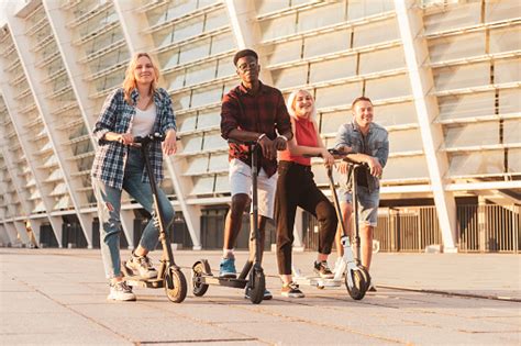 도시에서 전기 스쿠터를 들고 웃고 있는 다인종 청소년들 생태 교통 임대 개념 전기 스쿠터에 대한 스톡 사진 및 기타 이미지