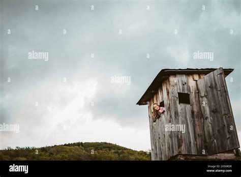 Girl In Hunting Blind During Their Walk In Forest Climbing Up To Observe Beautiful Spring