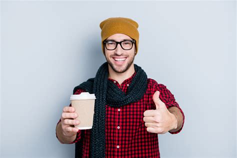 명랑의 초상화 닫기 만족 잘생긴 입고 체크 무늬 빨간색 셔츠가 주는 일회용 종이 컵 및 회색 배경에 절연 엄지손가락 업 기호를 보여주는 흥분 아침 식사에 대한 스톡 사진 및