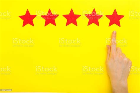 5 별 은 등급 고객 경험 개념을 증가 서비스 등급을 높이기 위해 5성 기호를 넣는 클라이언트의 손 노란색 배경에 5 개의 빨간