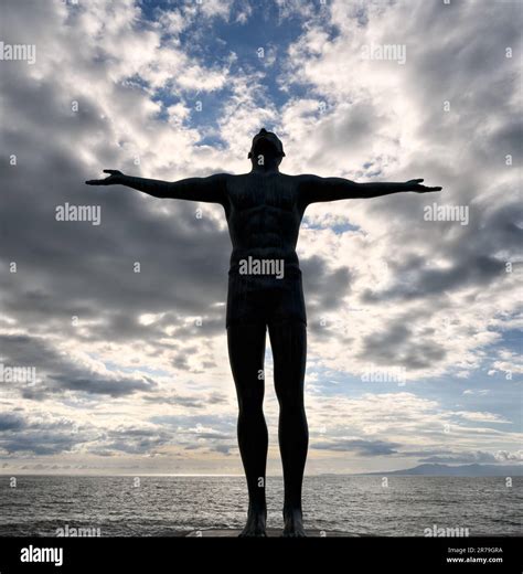 A Silhouette Of A Man With Outstretched Arms Looking Up To The Sky