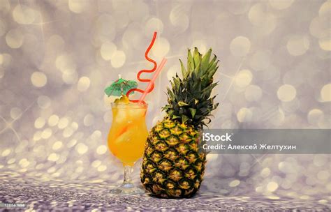 회색 추상적 배경에 잘 익은 파인애플 근처 얼음과 빨대를 가진 밝은 노란색 음료의 키가 큰 유리 각얼음에 대한 스톡 사진 및 기타 이미지 Istock