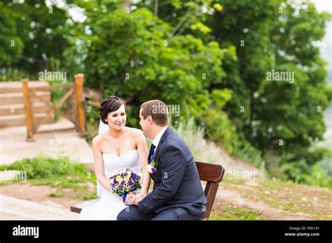 Attractive Bride And Groom Sitting On A Bench Stock Photo Alamy