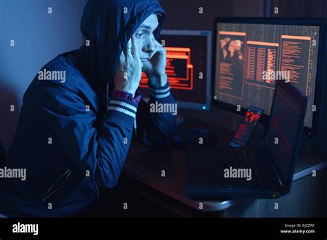 a male hacker in a hood thinking about the problem of hacking or