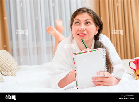 Woman Lying On Bed With Pen And Notepad Hi Res Stock Photography And Images Alamy