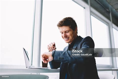 넷북과 동기화 현대 스마트 워치에 공식적인 착용 확인 알림에서 번영 사업가 웨어러블 컴퓨터 주최자 및 터치 스크린에 만족 웃는 남성 기업가 감독에 대한 스톡 사진 및 기타