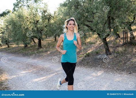 Caucasian Running Blonde Girl Jogging Outdoors On Oad Stock Image