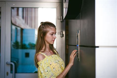 Premium Photo Young Woman Entering Password On Security System By Door