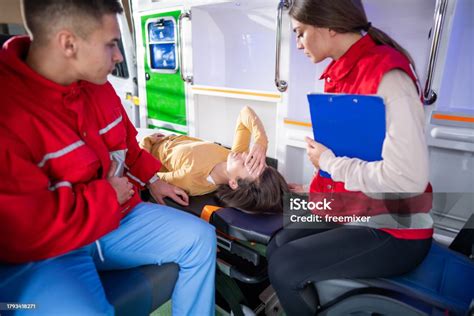 구급차에서 들것에 누워 있는 젊은 여성 의사와 구급대원이 응급 처치를 하고 있다 20 24세에 대한 스톡 사진 및 기타 이미지 20 24세 25 29세 3 명