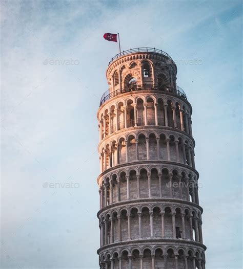 Low Angle Shot Of The Leaning Tower Of Pisa Under A Blue Cloudy Sky In