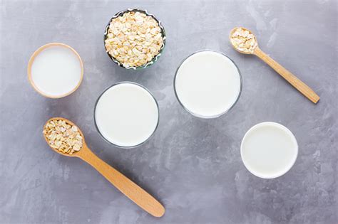 귀리 우유의 개념 나무 스탠드에 유기농 귀리 우유 비건 비 유제품 대체 우유 시멘트 배경에 건강한 비건 우유 폐기물 제로 맨 위 보기 플랫 레이 0명에 대한 스톡 사진 및