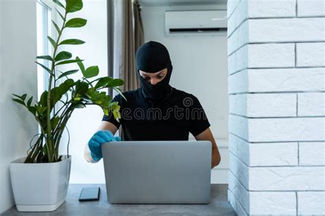 Hacker Man In Black Hood And Mask With Computer Laptop Hacking System In Digital Intruder Cyber
