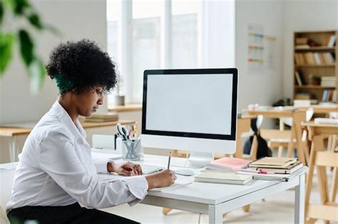 Premium Photo African American Teacher Sitting At Her Workplace With Computer In Class And