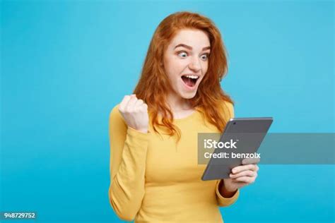 뭔가 각종 디지털 테이블에 웃 고 행복 세로 젊은 아름 다운 매력적인 부드러운 생강 Redhair 여자를 닫습니다 블루 파스텔 배경입니다 공간에 복사 합니다 귀여운에 대한