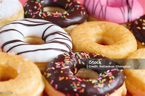 초콜릿 설탕 프로 스 팅과 모듬된 도넛 토 핑 도넛 다채로운 다양 한 스프링 및 다양 한 멀티 컬러와 달콤한 도넛의 맛 믹스 호랑이 핑크 바탕에 뿌려 상위 뷰 도넛에 대한