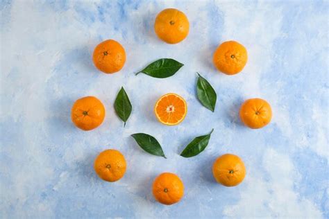 Premium Photo Pile Of Clementine Mandarins And Leaves On Blue Background