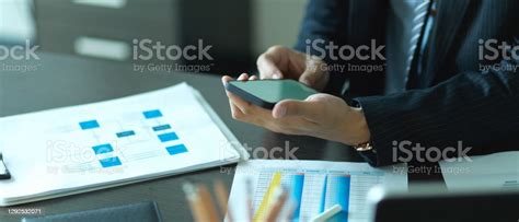 사무실 책상에서 비즈니스 정보로 작업하는 동안 스마트 폰을 사용하는 사업가 손 그래프에 대한 스톡 사진 및 기타 이미지 그래프 남자 남자 사업가 Istock