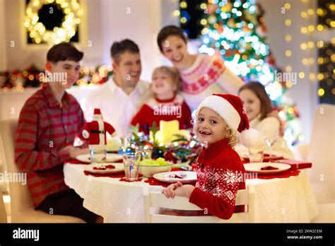 La famille avec des enfants dînatoire de dinde Noël au foyer et décoré arbre de Noël Parents