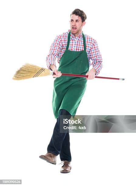 전체 길이1 인정면 보기 2029 세 성인 잘 생긴 젊은 남자남성 착용 깅감청바지앞치마 심각 하 고 싸우는 자세싸움펀치들고 빗자루를 보여주는 앞면 20 29세에 대한 스톡