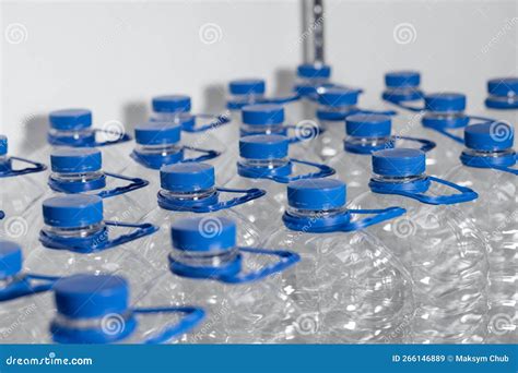 Many Empty Water Bottles With Lids And Handles Are Lined Up In A Display Case View From Above